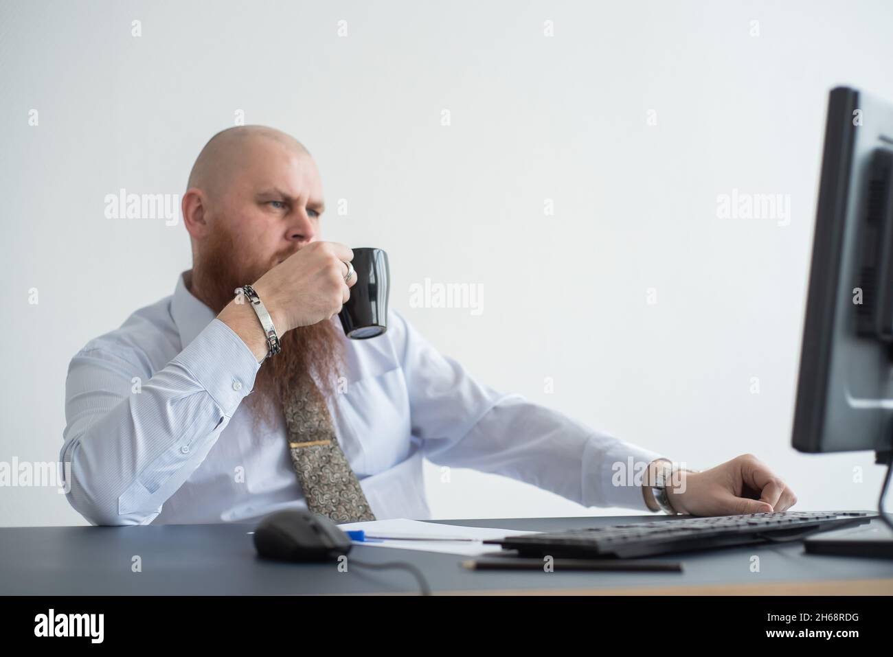 Problems for the office worker. A bald man in a white shirt sits at a ...