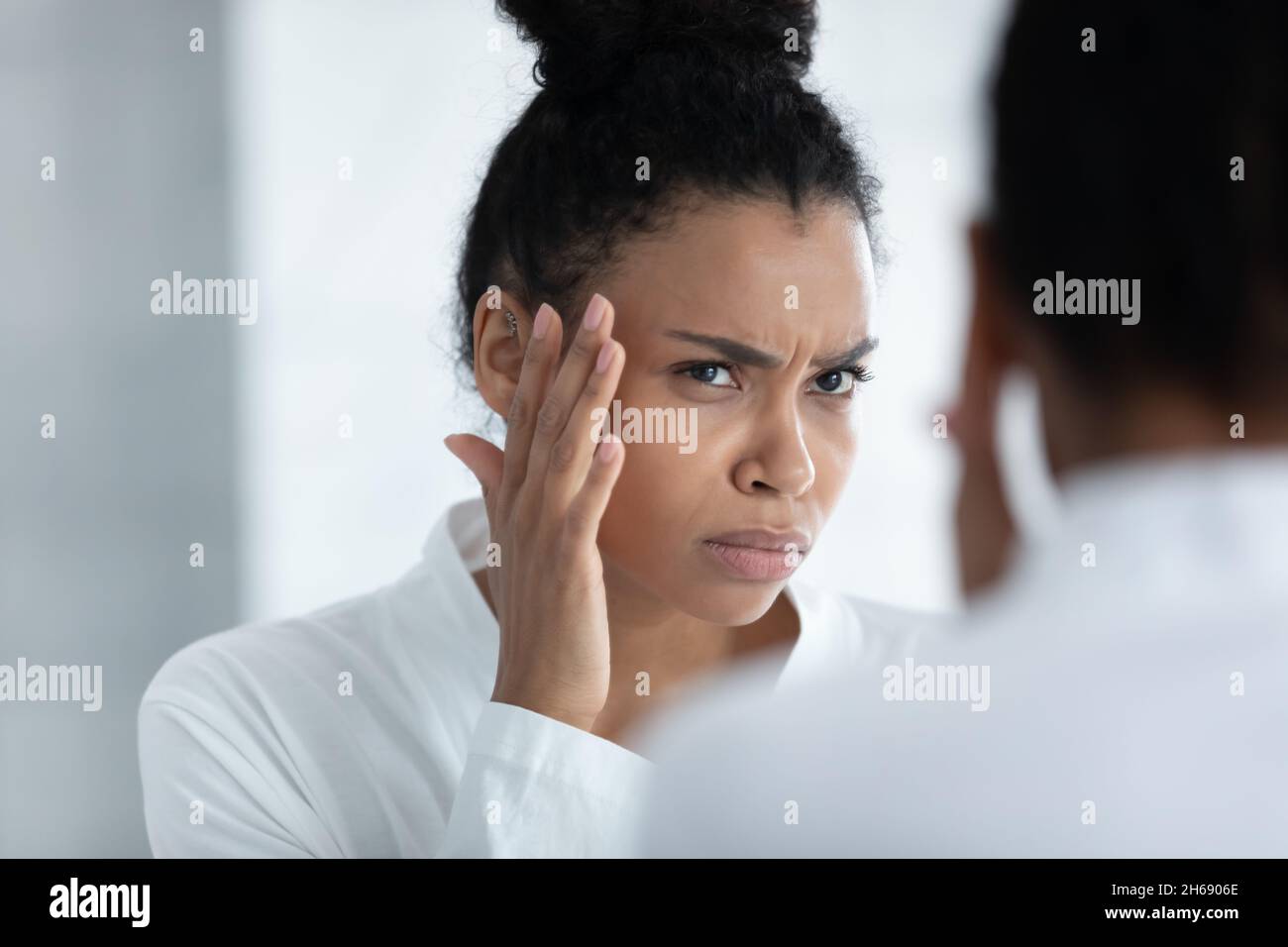 Stressed young african american woman worrying about first wrinkles ...