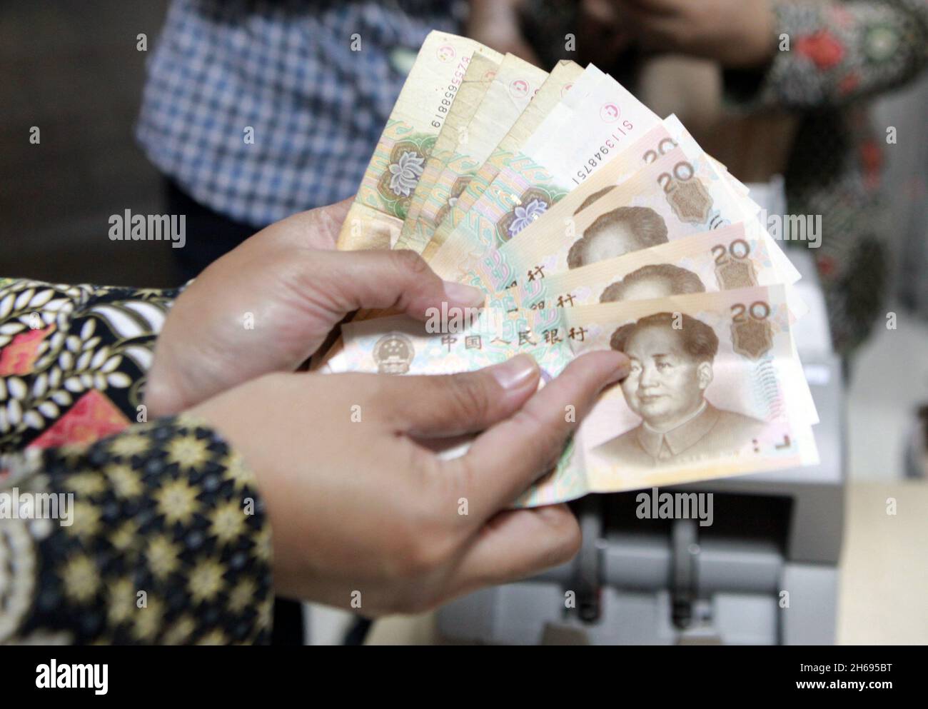 Hands holding chinese yuan hi-res stock photography and images - Alamy