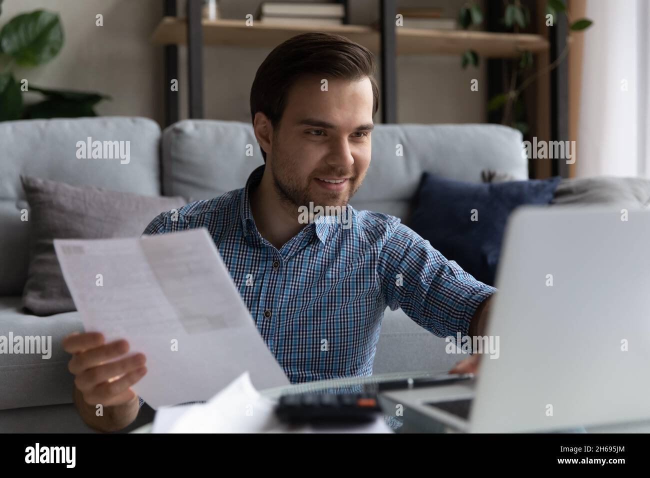 Happy young handsome man managing monthly budget Stock Photo - Alamy