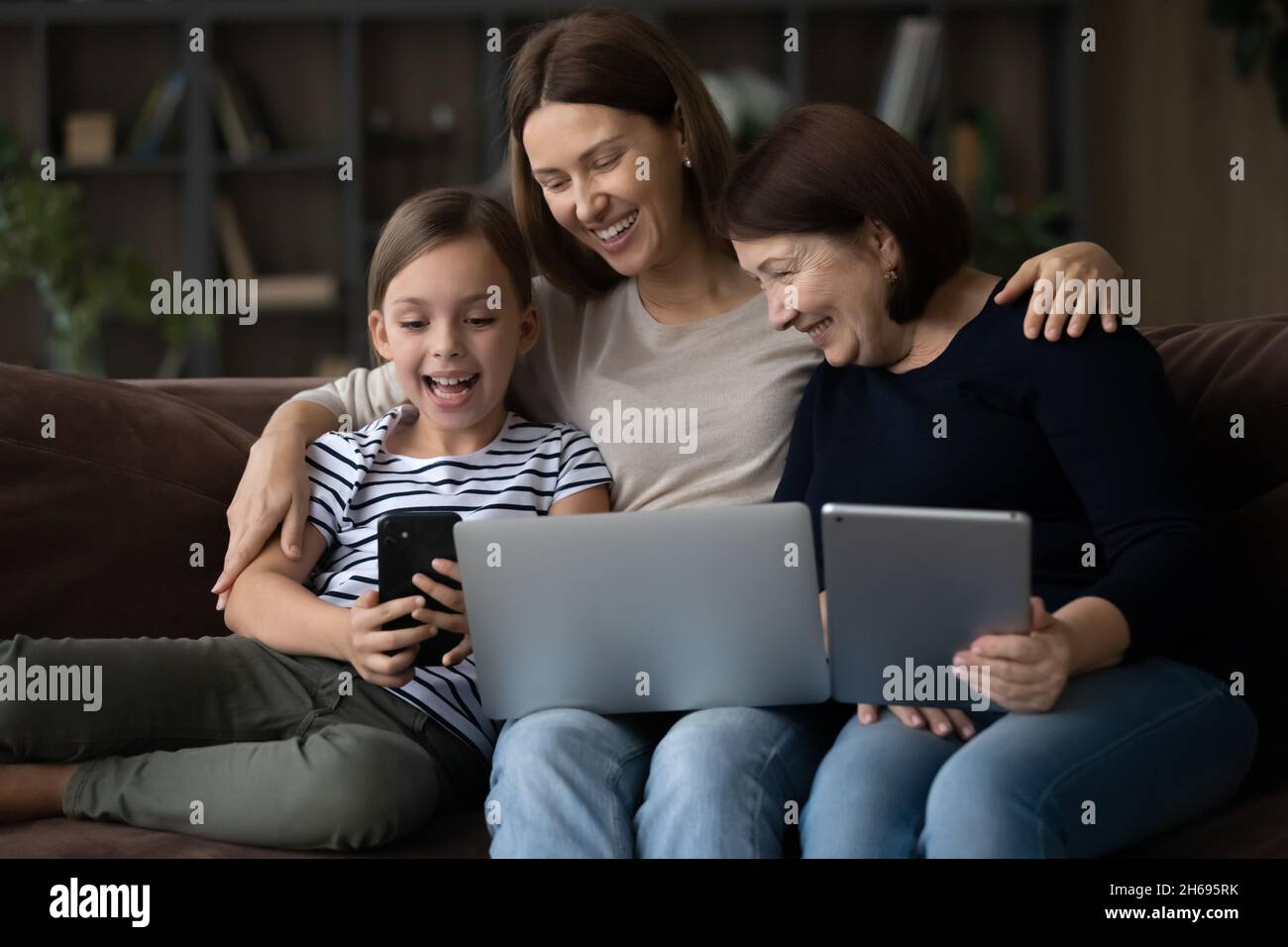 Happy three generations of women using modern devices together Stock ...