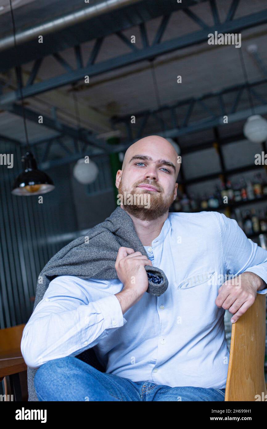 White european bald man with beard and grey eyes in the workspace with ...