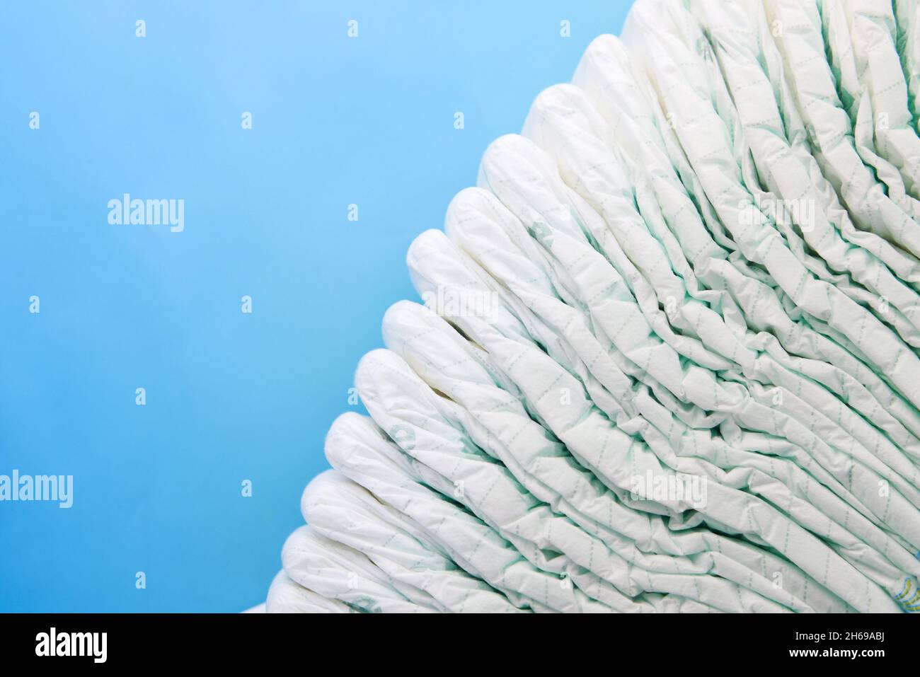 stack of baby diaper on blue background with copy space Stock Photo - Alamy
