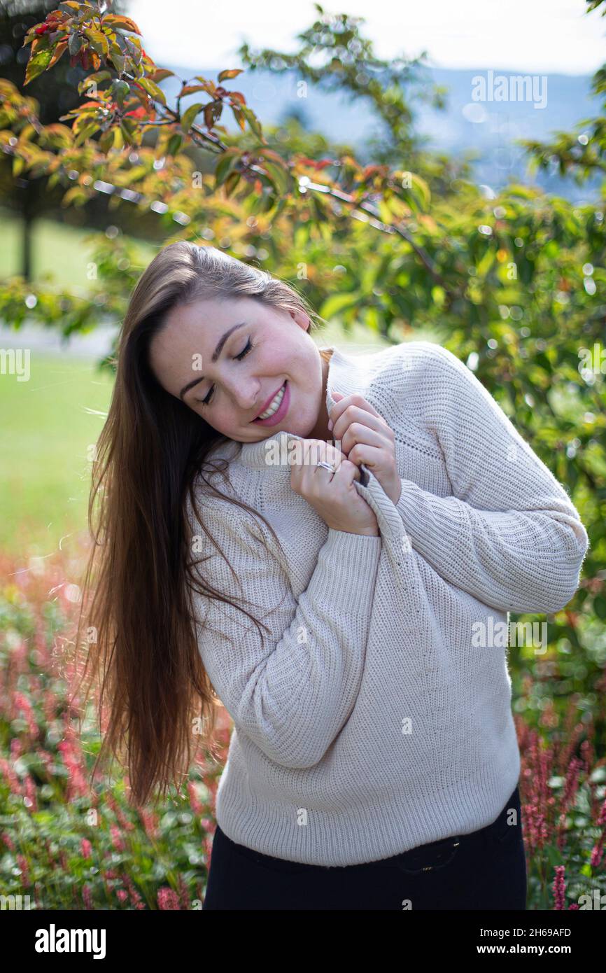 European young woman with long straight hair in pullover outside Stock ...