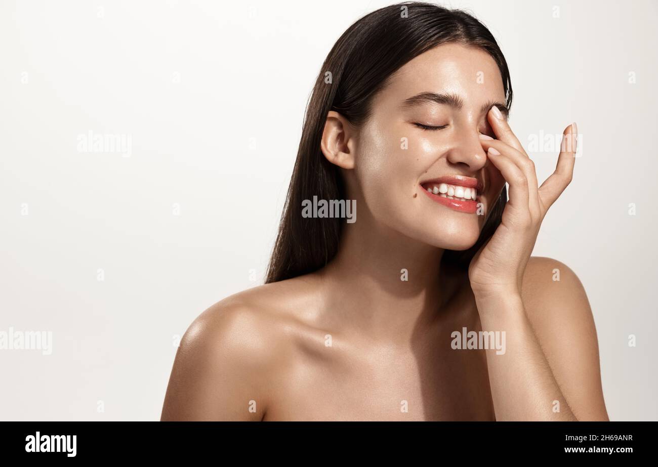 Laughing and smiling model with healthy skin and white teeth, touching ...