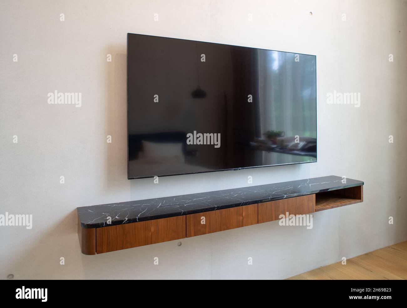 Modern interior of luxury apartment. TV on white wall. Wooden drawers ...