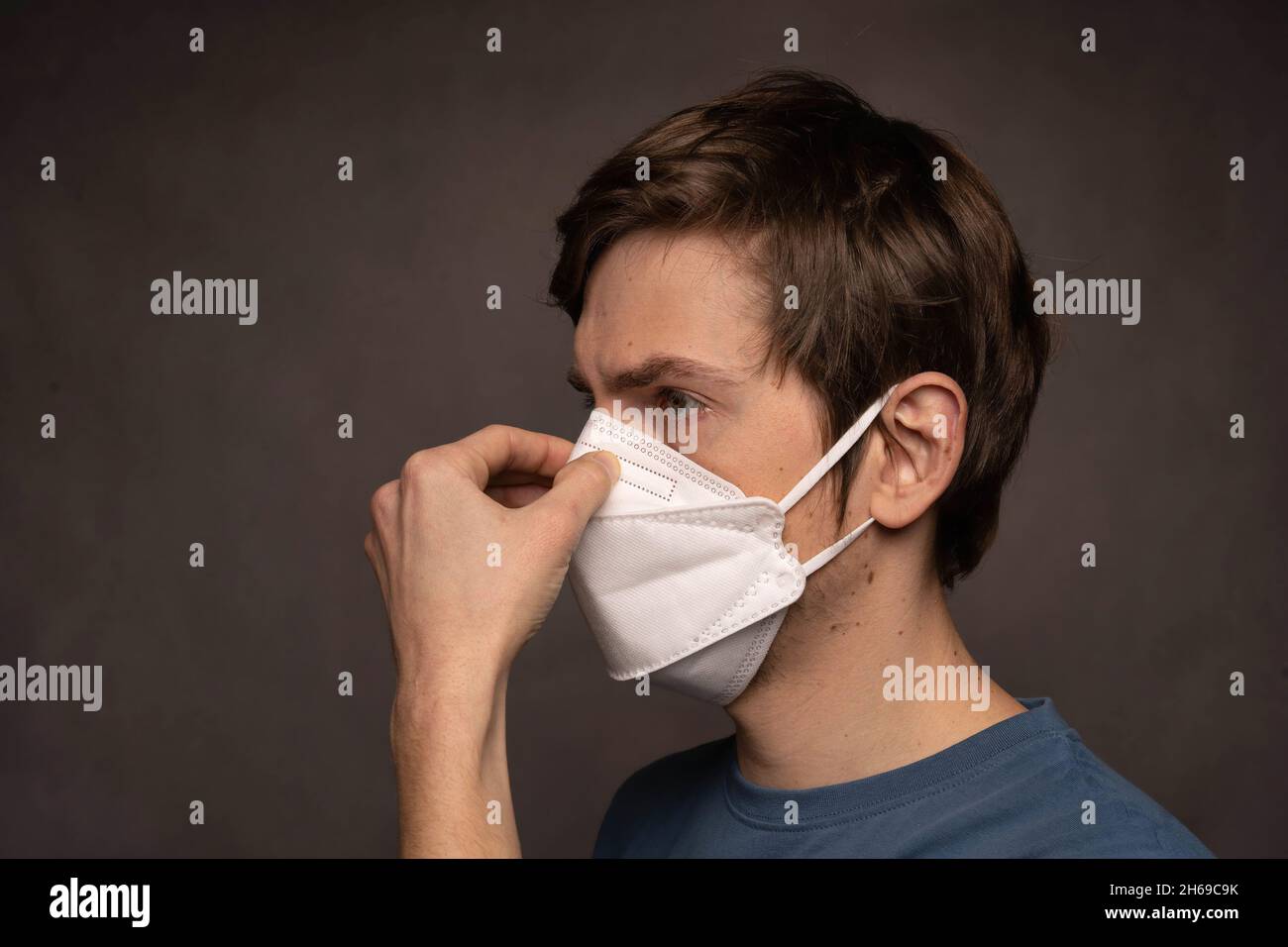 Young handsome tall slim white man with brown hair holding his nose ...