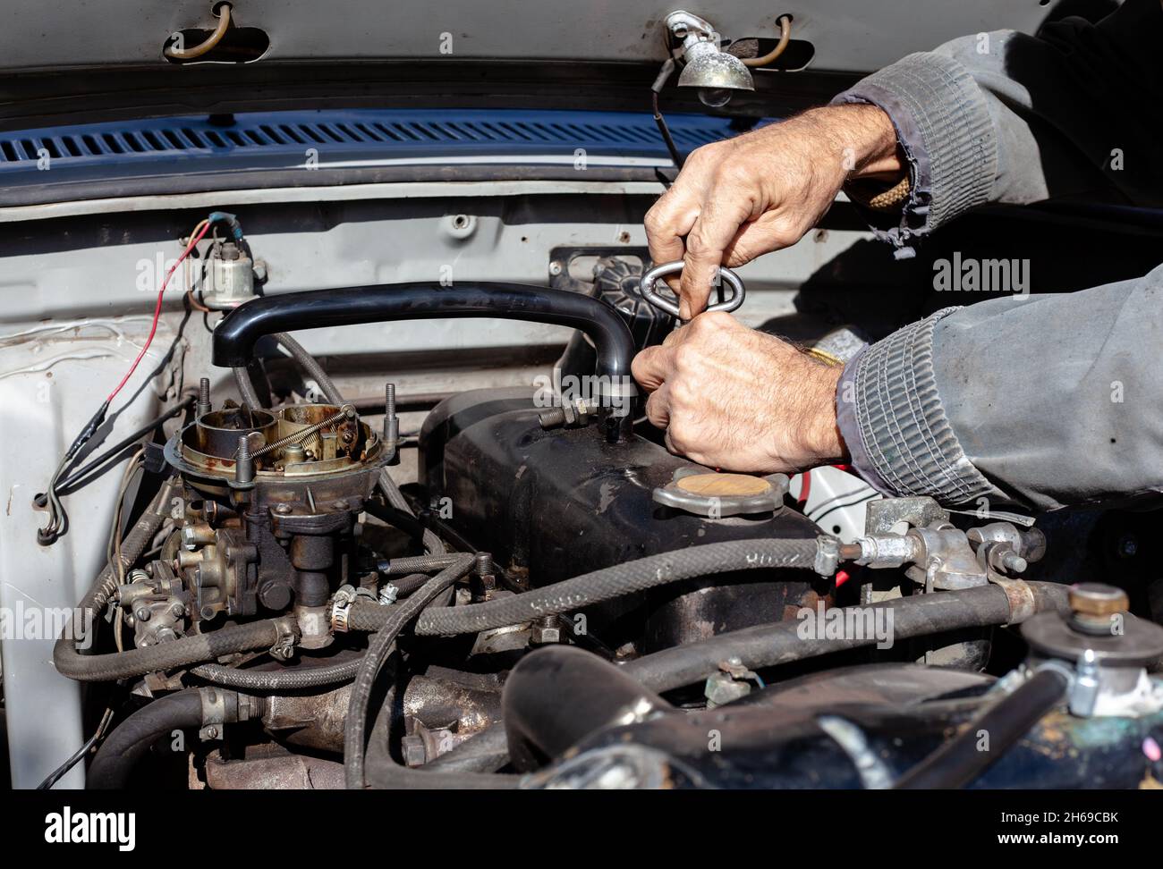 the mechanic uses a screwdriver to disassemble old engine. DIY repair ...