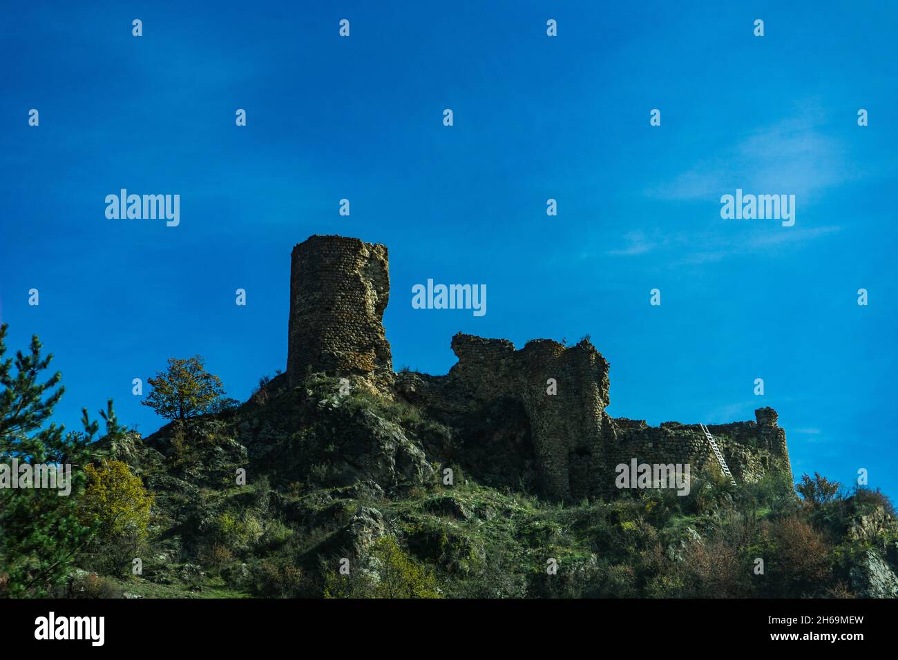 Ruins of medieval castle on the hilltop of Caucasus mountains in ...