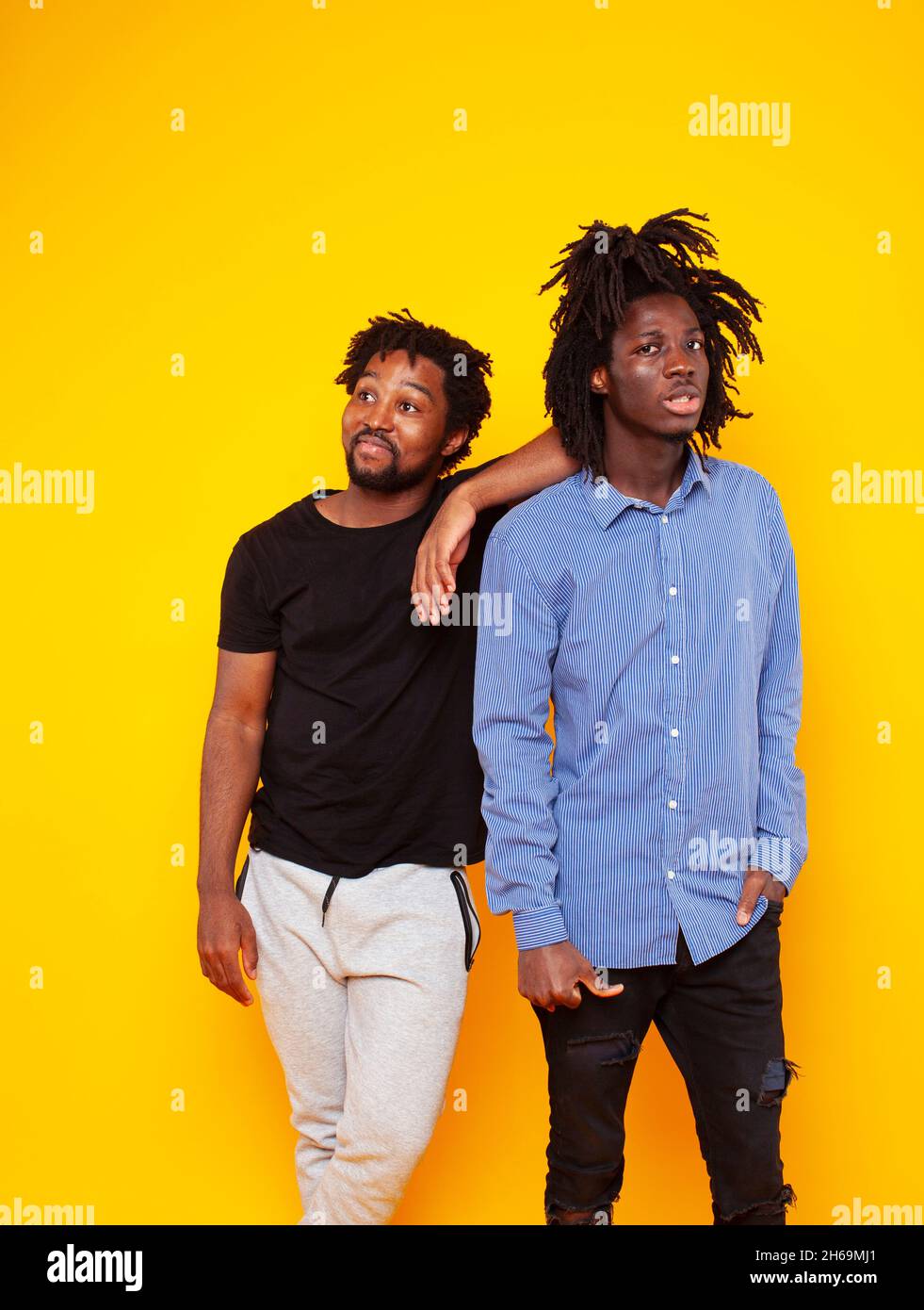 two african american guys posing cheerful together on yellow background ...
