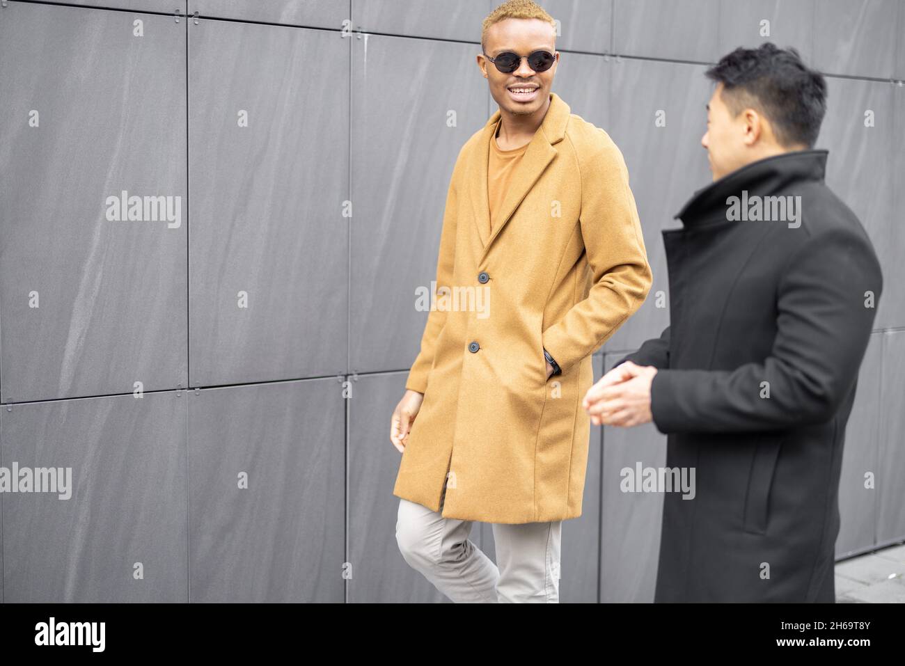 Businessmen walking on city street and talking Stock Photo - Alamy