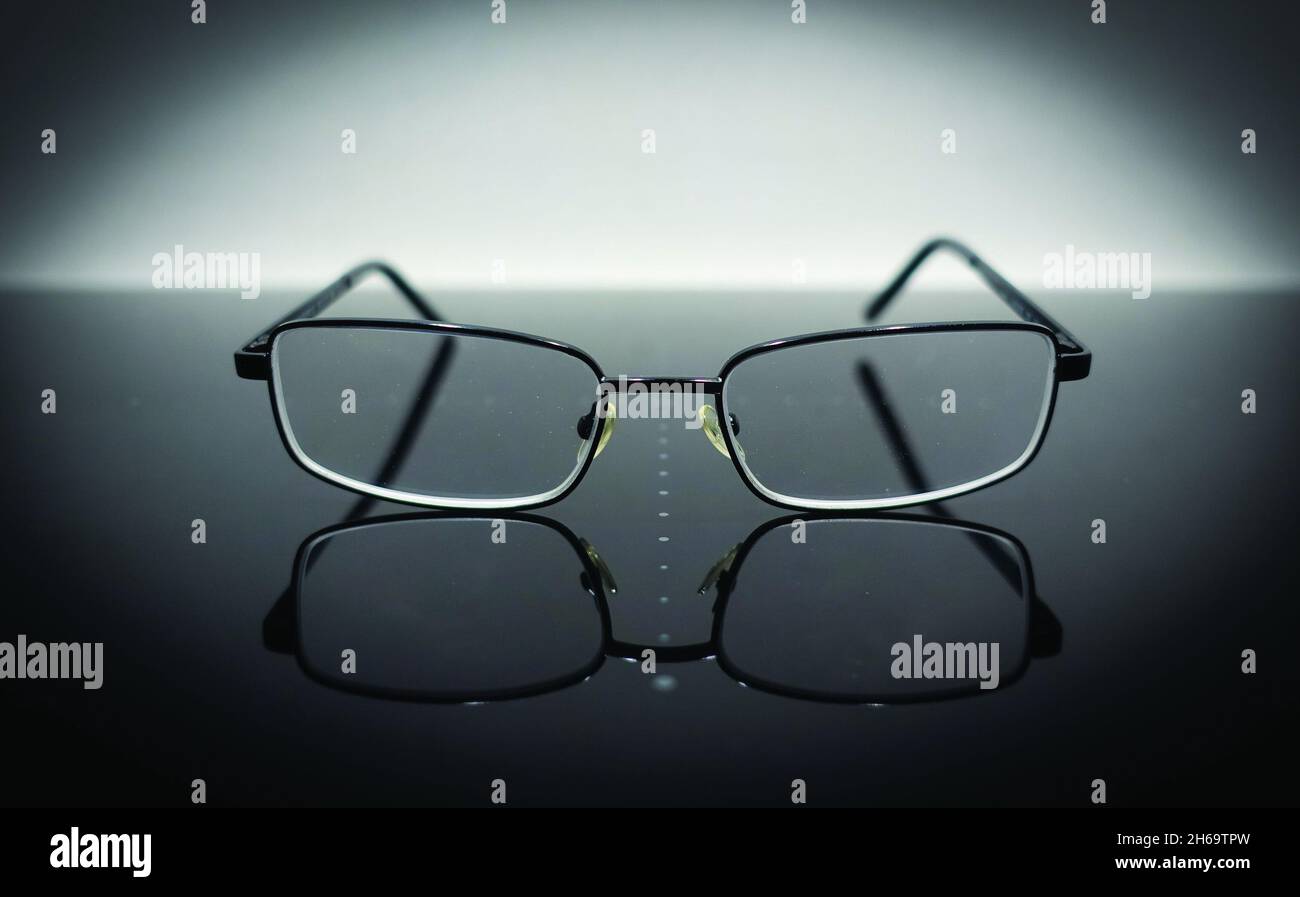 A selective focus shot of optical glasses on a mirroring surface Stock ...