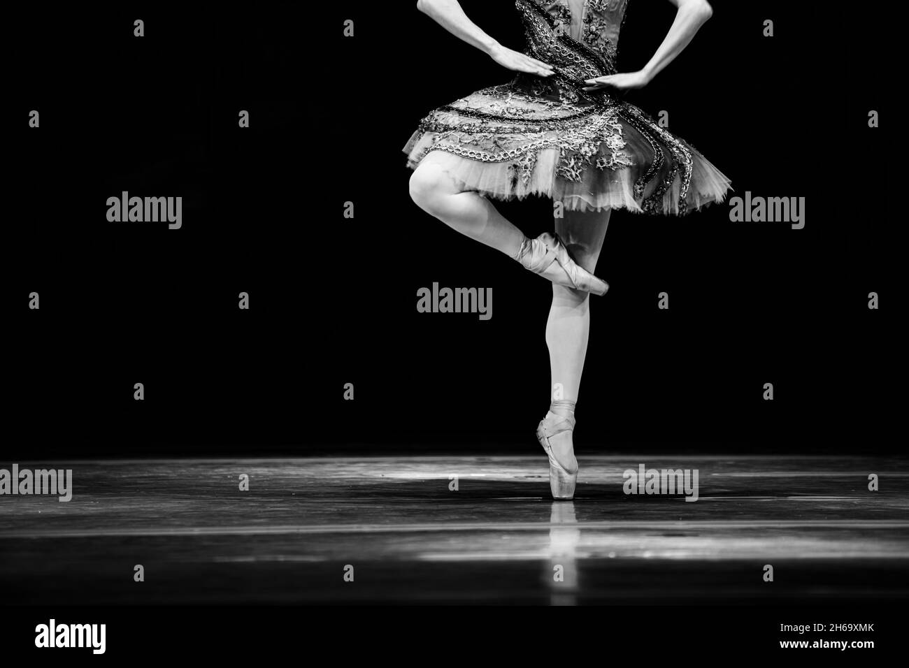 Closeup of ballerina dancing isolated on stage. Ballerina legs closeup ...