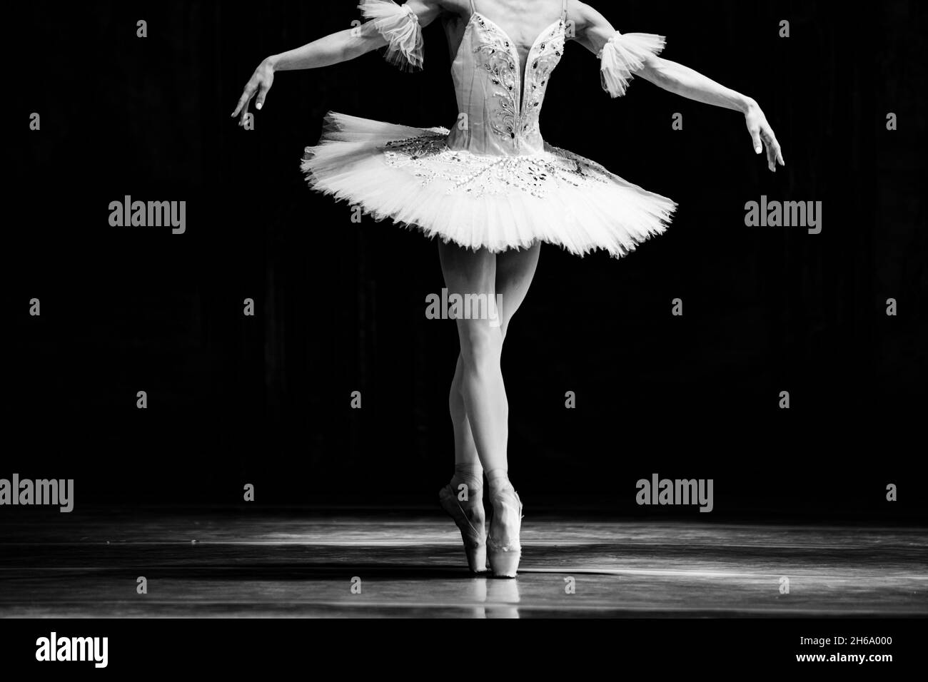 Closeup of ballerina dancing isolated on stage. Ballerina legs closeup ...