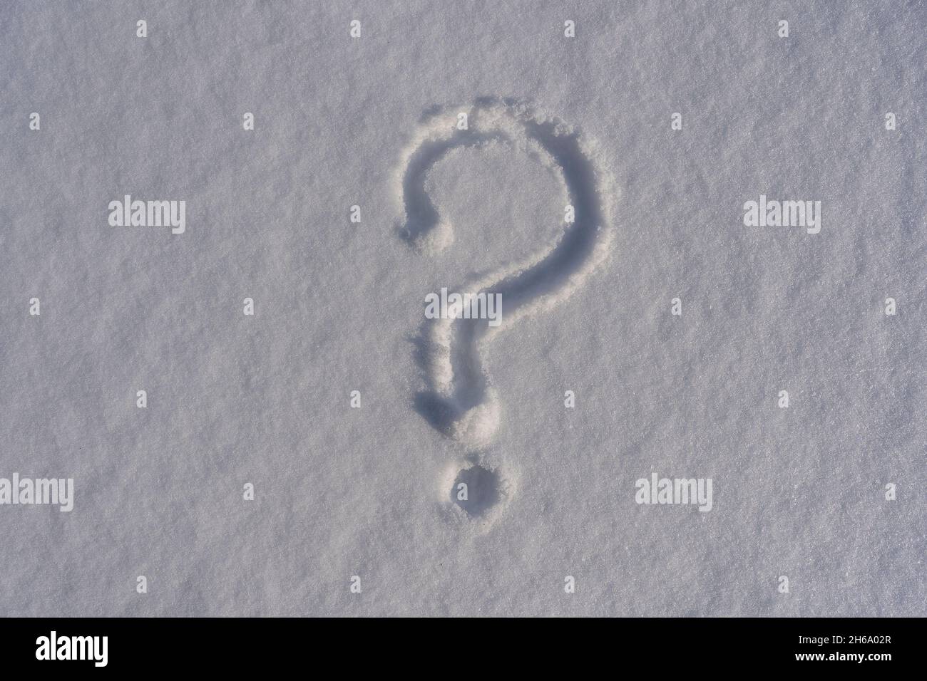 Question mark on a white fresh snow in winter, close up. Question mark ...