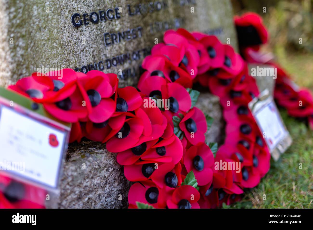 Red poppy wreaths laid on a war memorial in remembrance of war dead ...