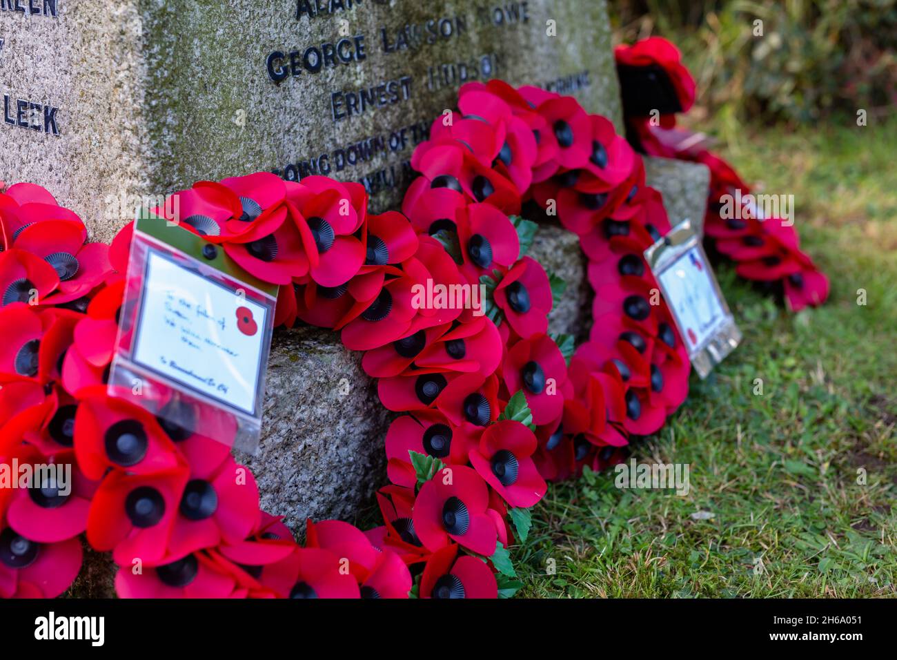 Red poppy wreaths laid on a war memorial in remembrance of war dead ...