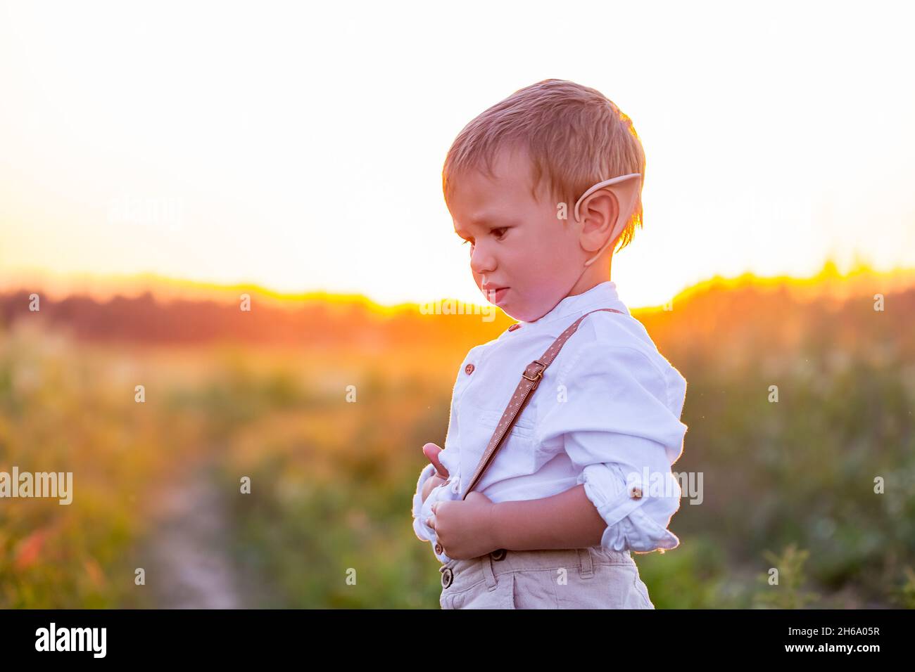 Crying little caucasian boy in a fairytale costume of elf in the summer ...