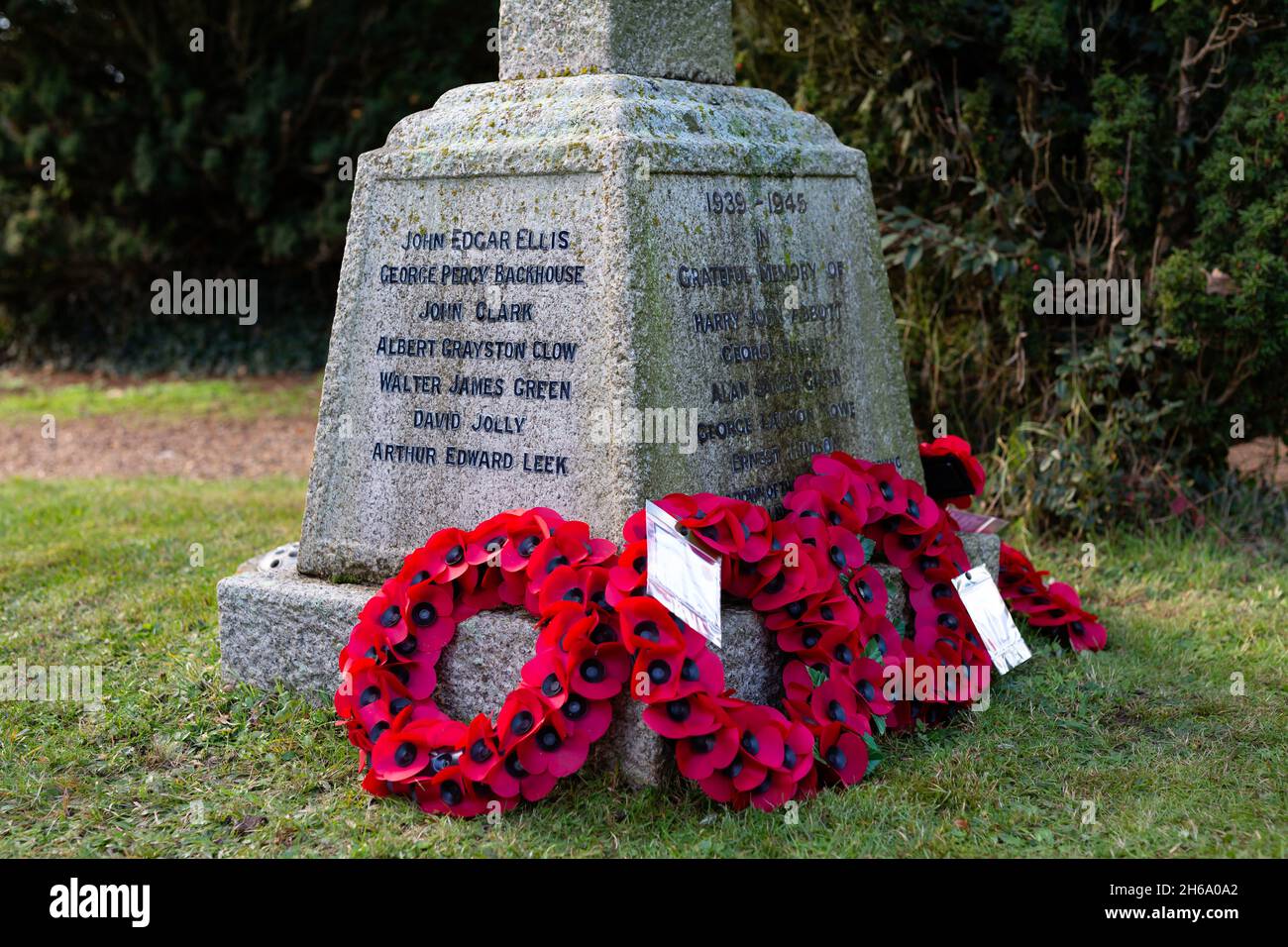 Red poppy wreaths laid on a war memorial in remembrance of war dead ...
