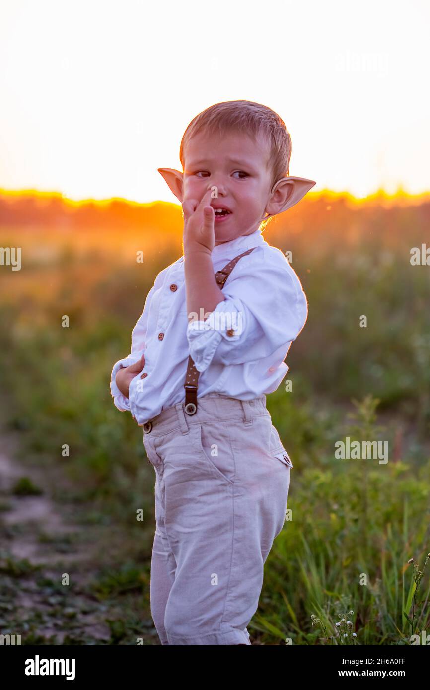 Crying little caucasian boy in a fairytale costume of elf picks the ...