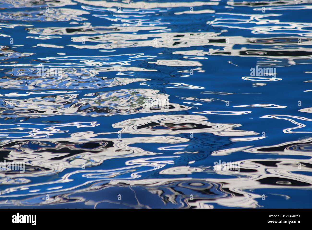 Patterns and colours in reflections of boats in harbour water Stock ...