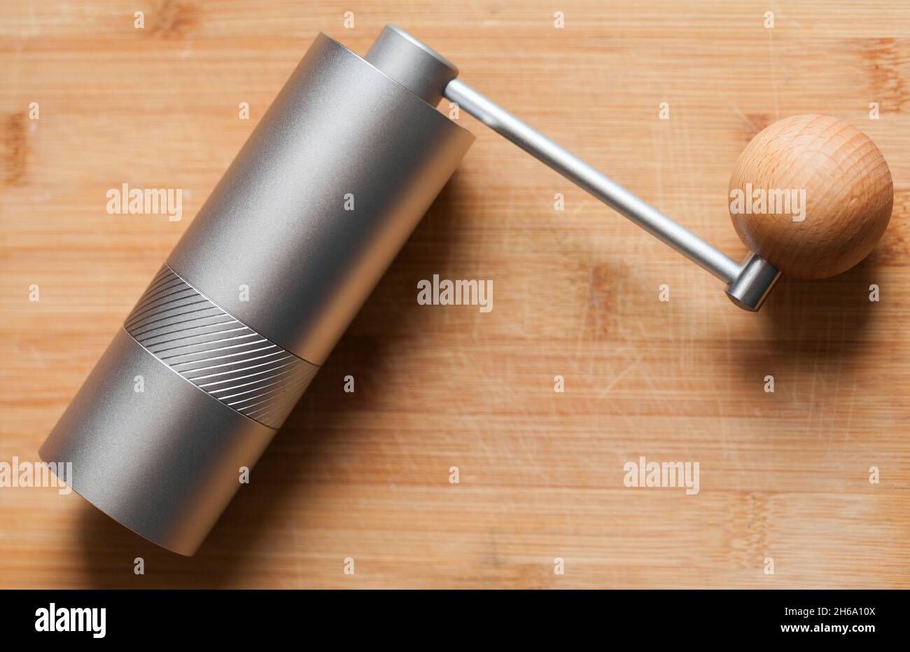 Modern manual coffee grinder lays on a wooden desk, professional ...