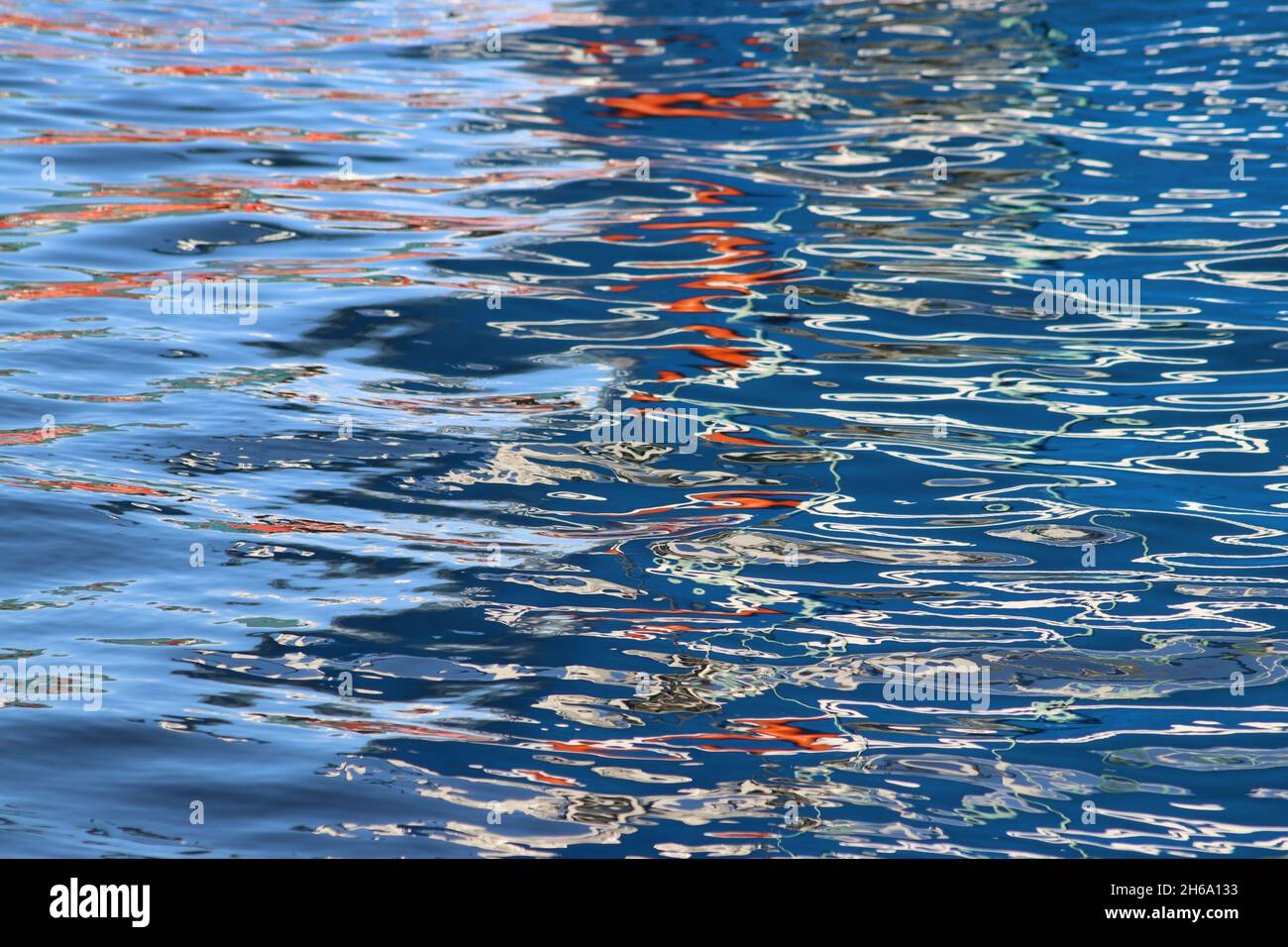 Patterns and colours in reflections of boats in harbour water Stock ...