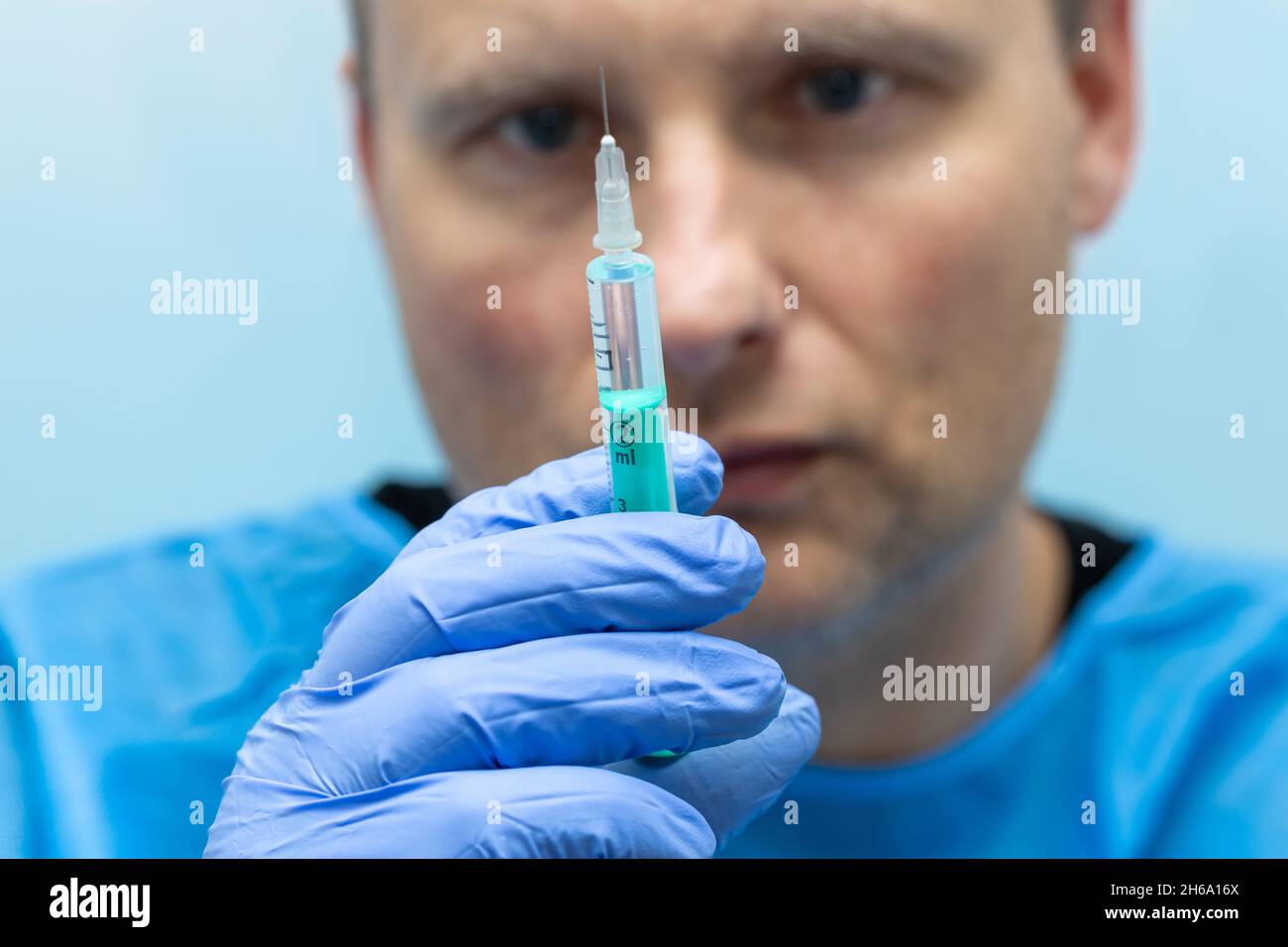 A paramedic holding a ready-to-use syringe in his hand Stock Photo - Alamy