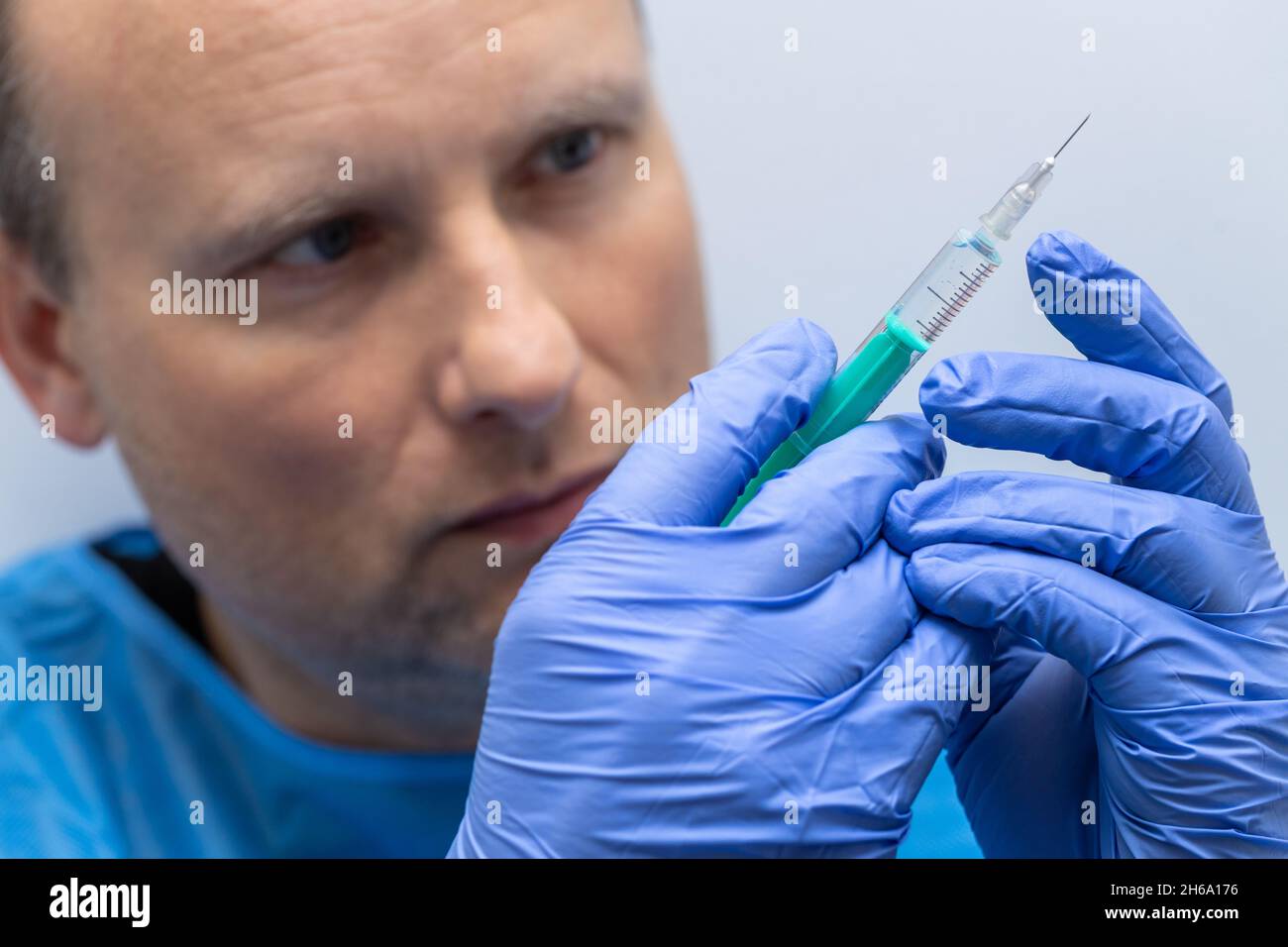 A doctor holding an injection syringe in his hand Stock Photo - Alamy