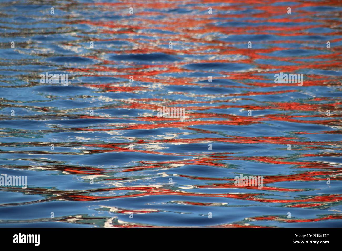 Patterns and colours in reflections of boats in harbour water Stock ...