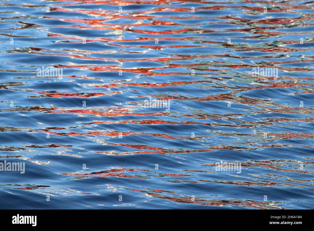 Patterns and colours in reflections of boats in harbour water Stock ...