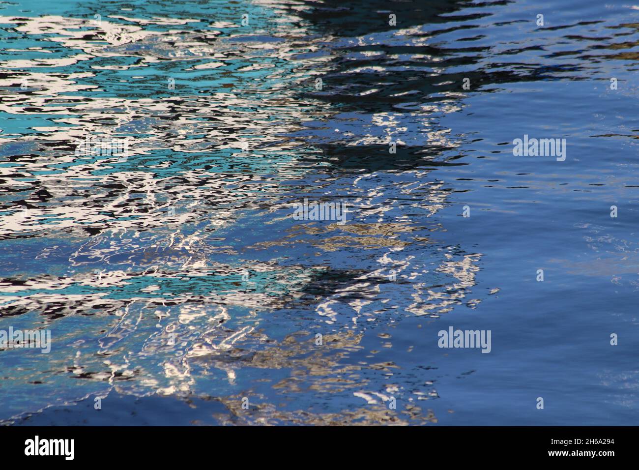 Patterns and colours in reflections of boats in harbour water Stock ...