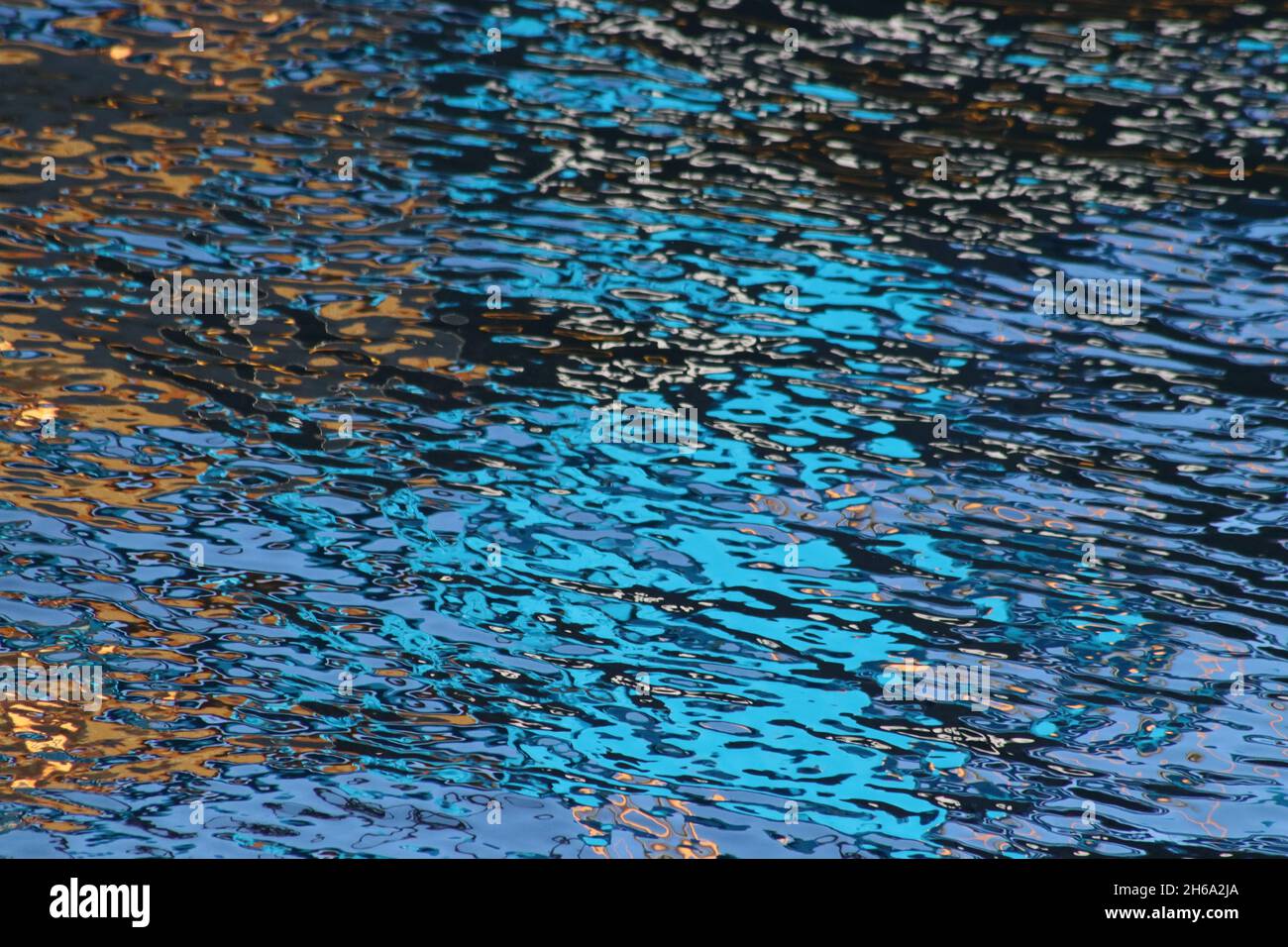 Shapes and colours in reflections of fishing boats in water of harbour ...