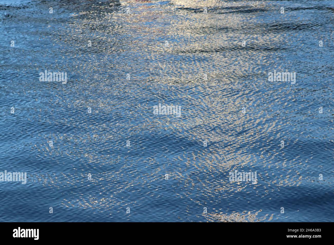 Shapes and colours in reflections of fishing boats in water of harbour ...