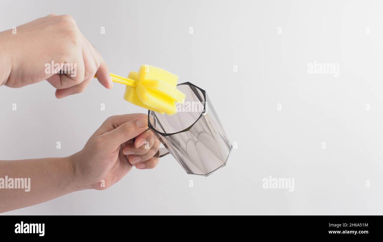 Clean and wash dish concept. Man hand washing drink glass on white ...