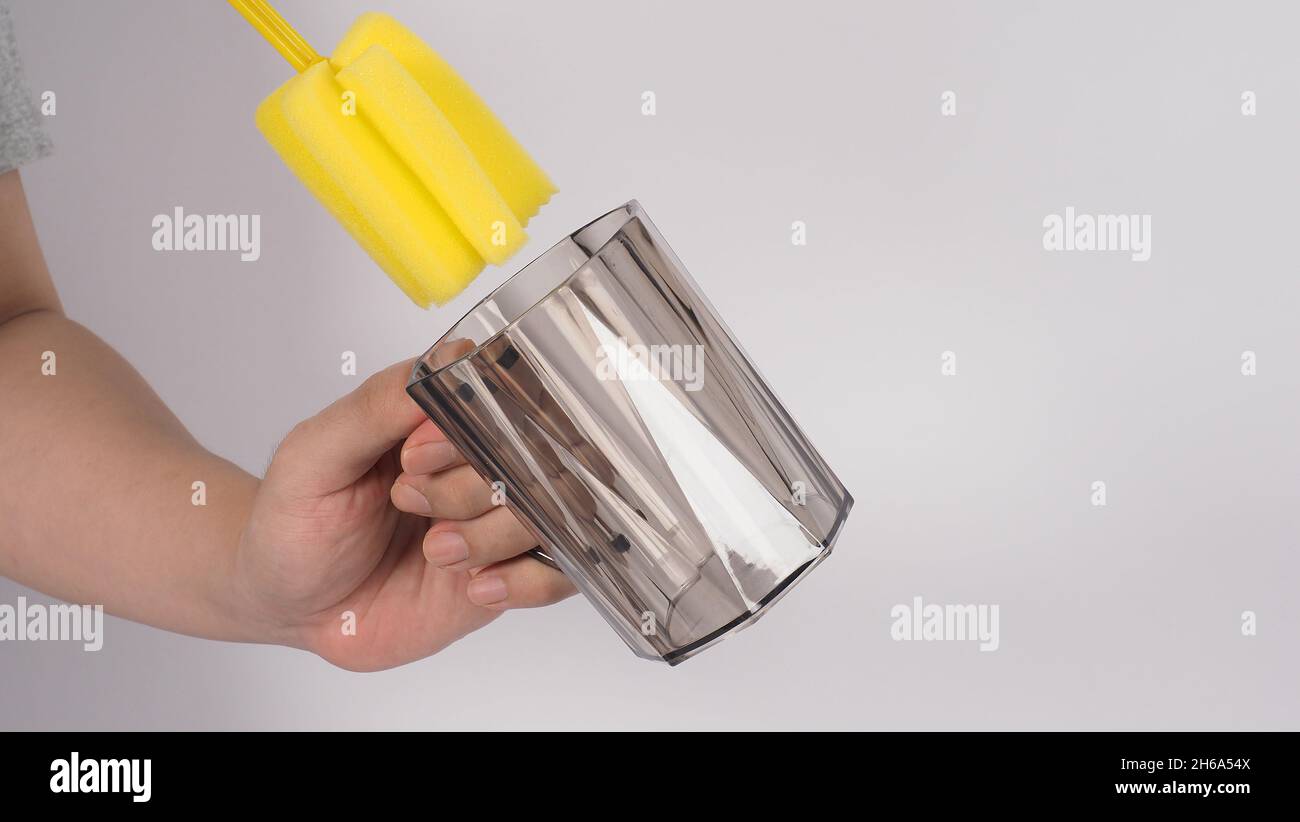 Clean and wash dish concept. Man hand washing drink glass on white ...