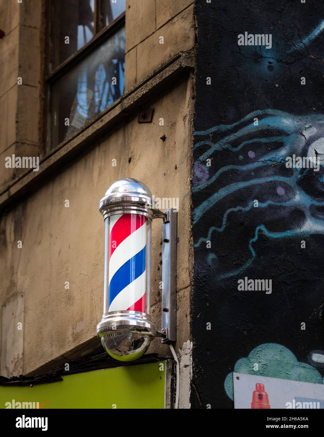 barber shop spiral pole on side of building in the city Stock Photo - Alamy
