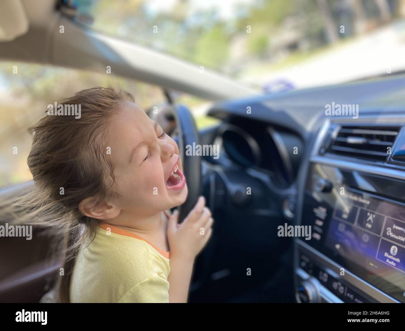 A closeup shot of a little girl pretending to drive a car Stock Photo ...