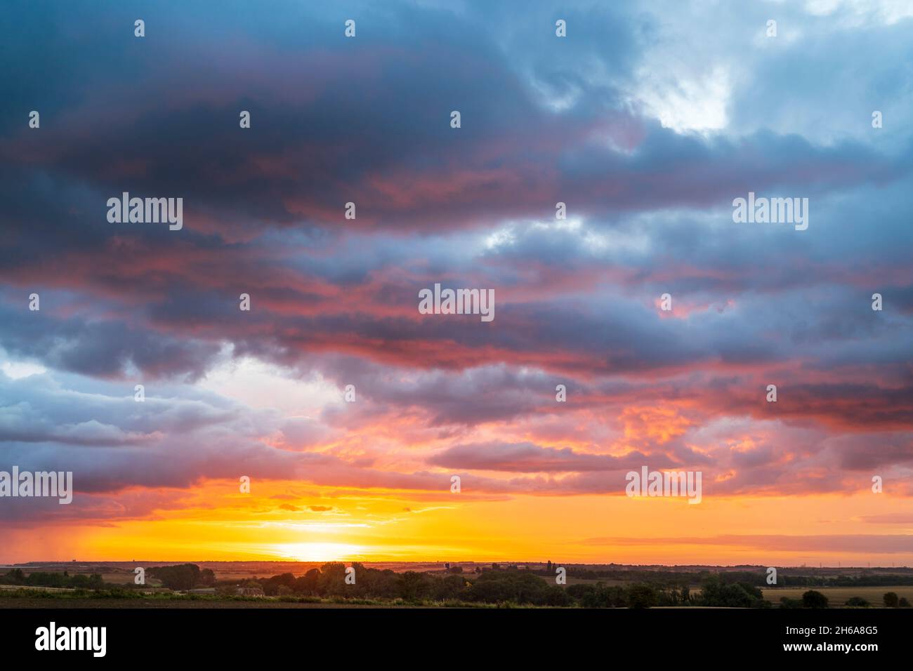 Sunrise above a mainly flat rural landscape in Kent with the Isle of ...