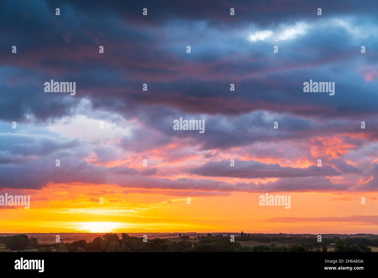 Sunrise above a mainly flat rural landscape in Kent with the Isle of ...