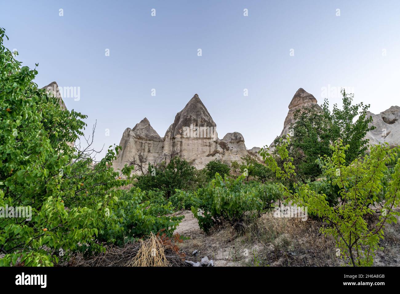 A landscape of a valley surrounded by old rock formations in Cappadocia ...