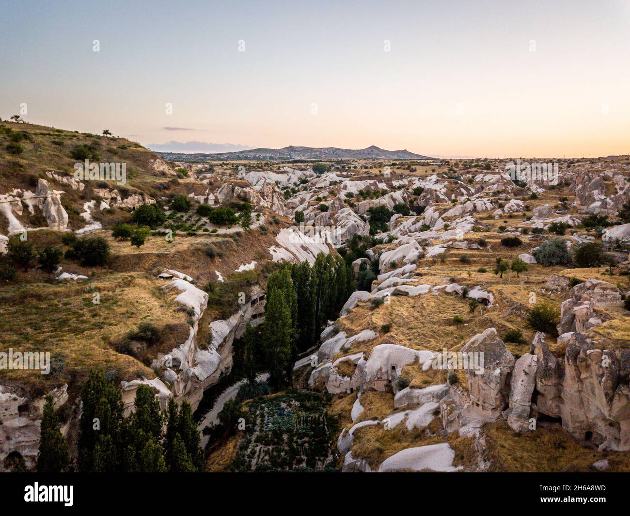 A landscape of rock formations and greenery in Cappadocia, Turkey Stock ...