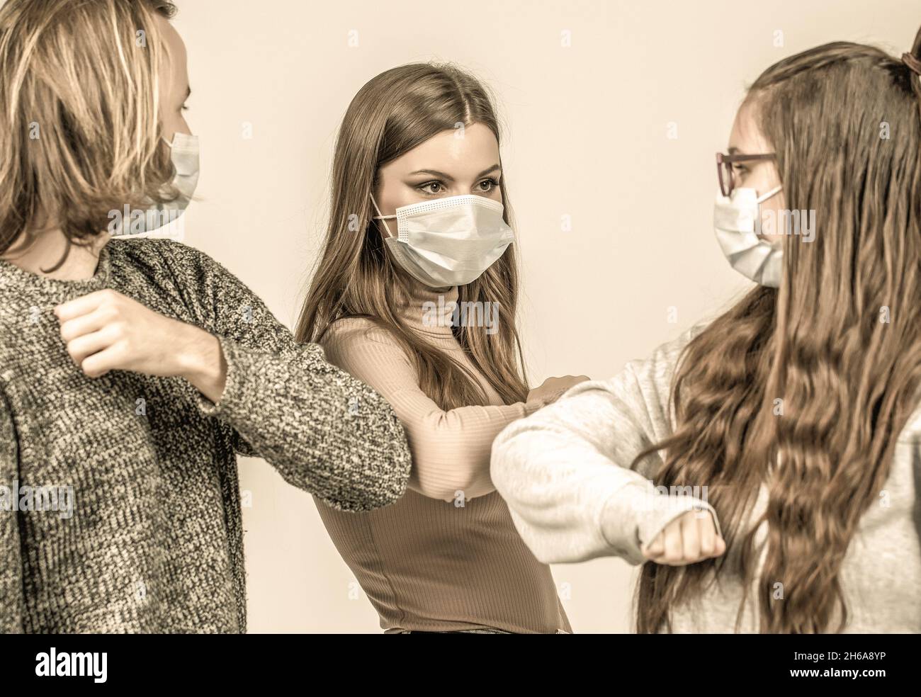 Elbows bump. Friends wearing protective face mask and greeting each ...