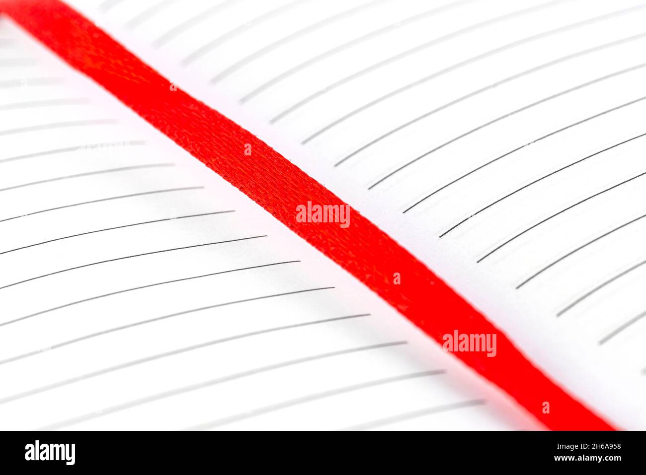 Macro photo of an open notebook with black lines and red ribbon ...
