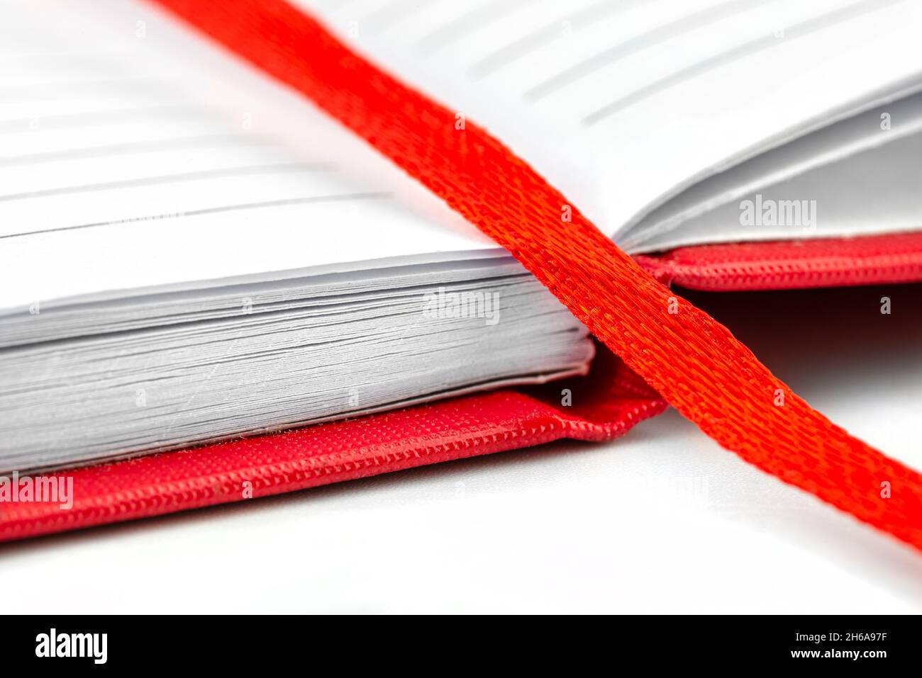 Macro photo of an open notebook with black lines and red ribbon ...