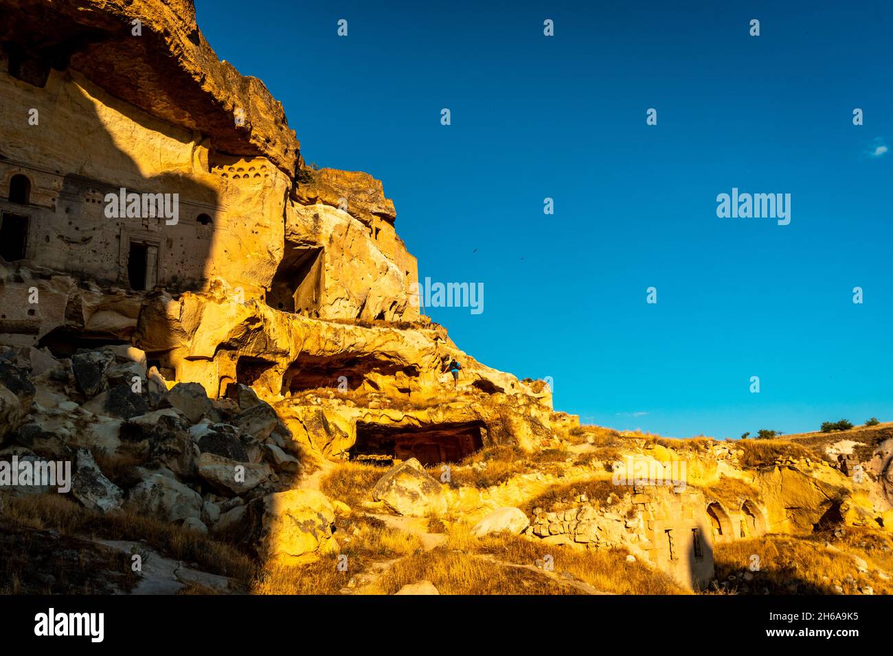 The ancient rock formations with holes on a hill in Cavusin, Cappadocia ...