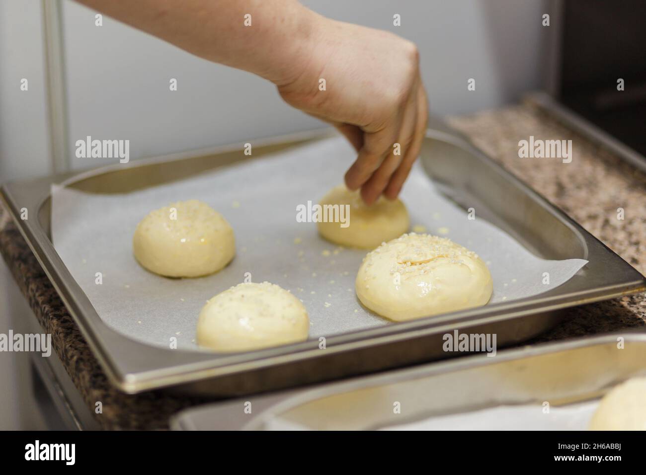 Preparing burger buns, making burgers. The hands of a chef sprinkling ...