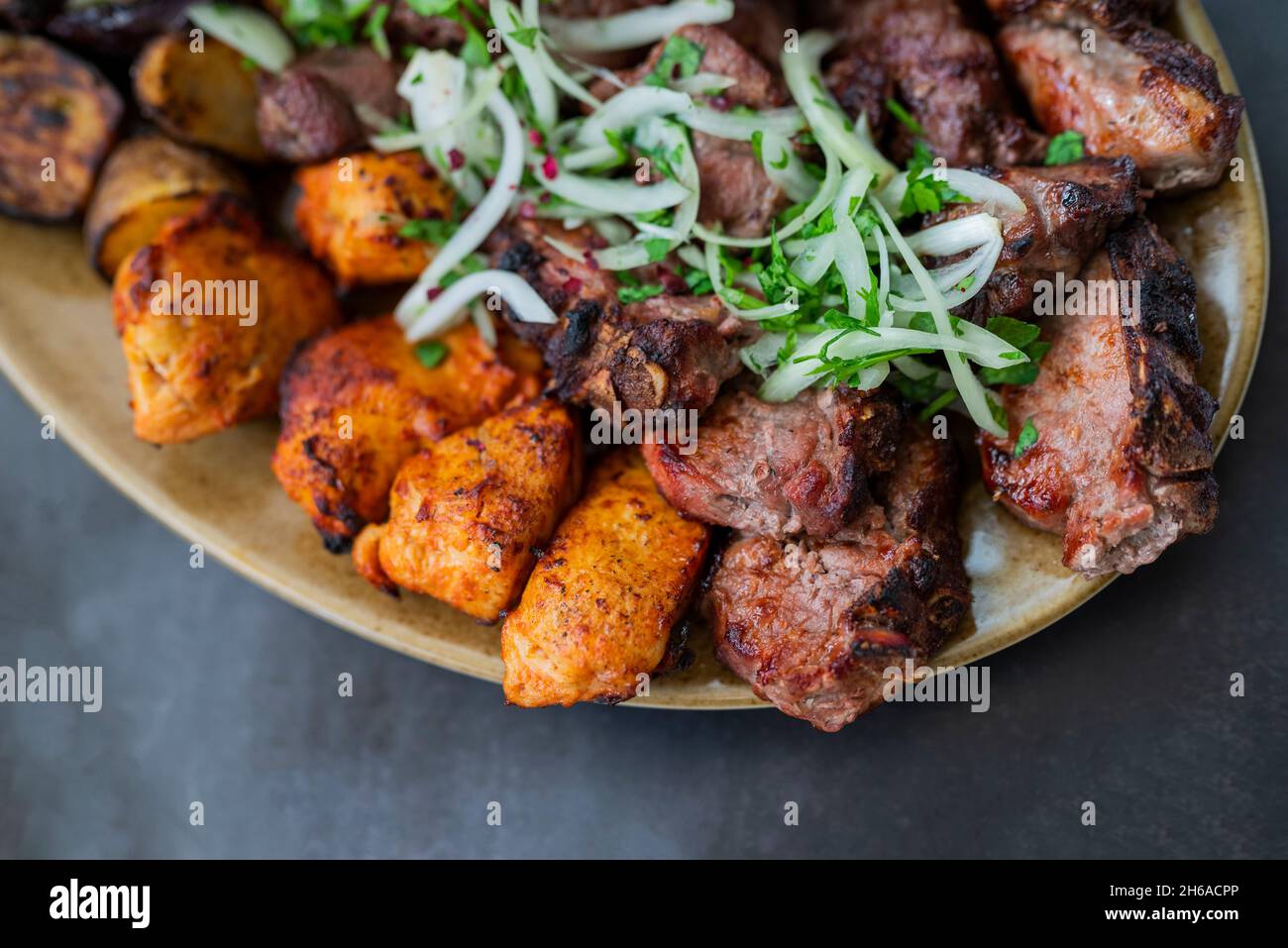 cuts of meat barbecue grilled pork and beef and chicken on a plate with ...