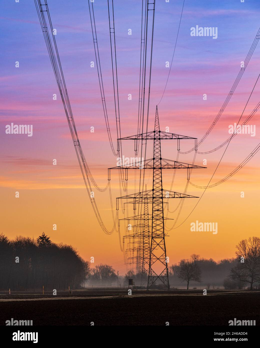Power lines at a colourful sunrise Stock Photo - Alamy