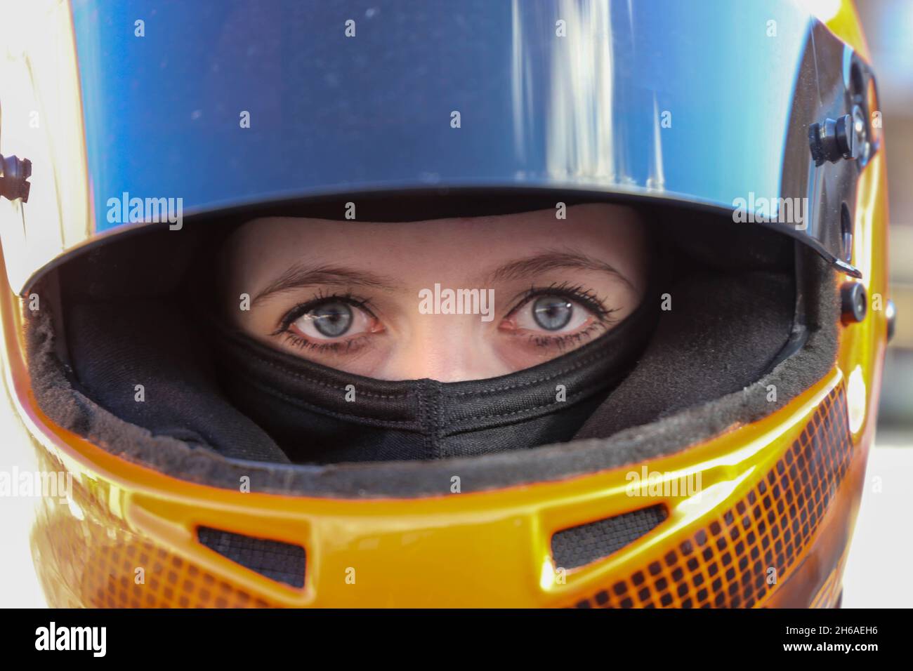 Female race car driver wears helmet and balaclava (model released Stock ...